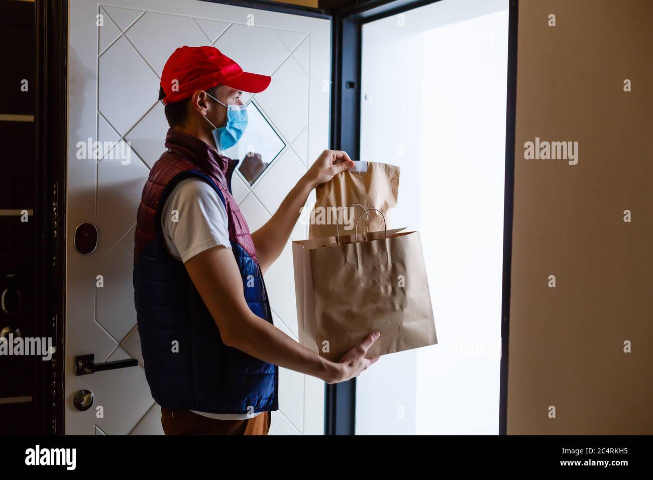 Delivery man holding paper bag with food on white background, food ...