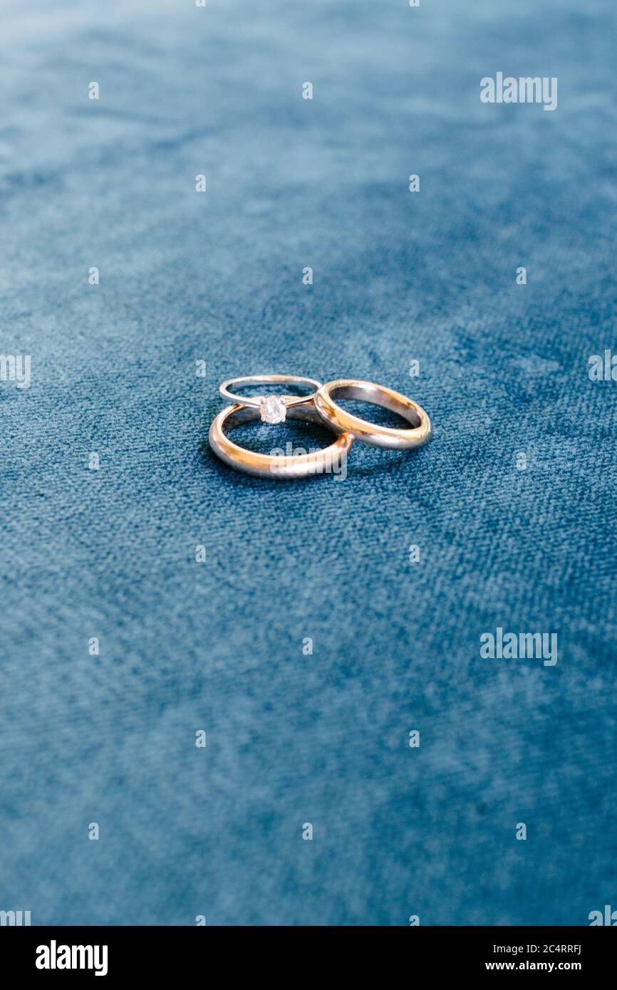 Diamond rings and wedding rings. Blue background. Wedding accessories ...