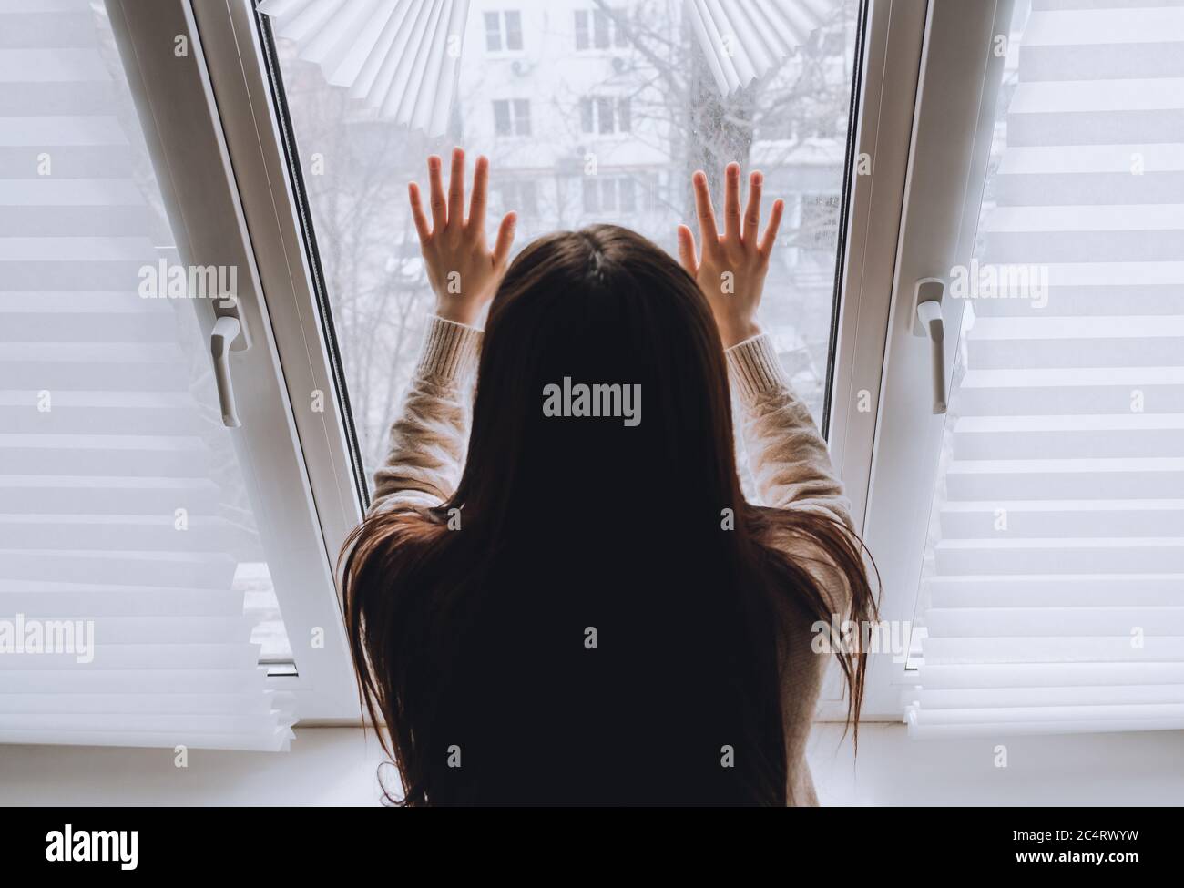 Female touches hands to the window glass Stock Photo - Alamy