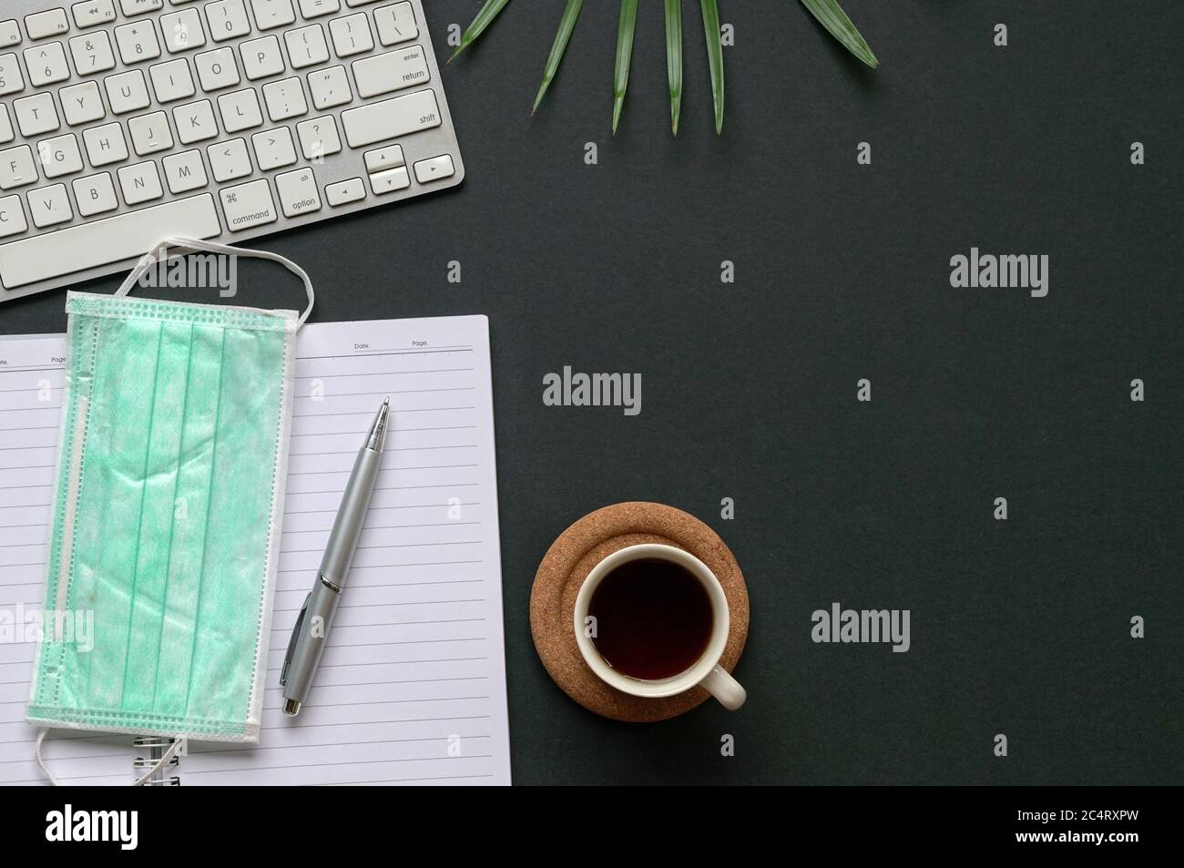 Top view of office desk with computer keyboard, medical face mask ...