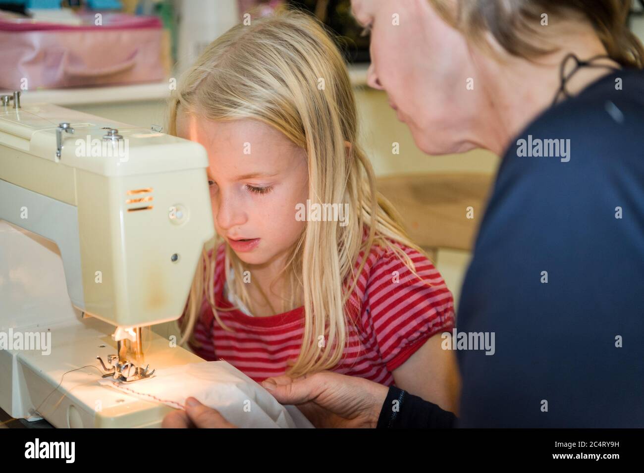 Teaching child girl sewing machine hi-res stock photography and images ...