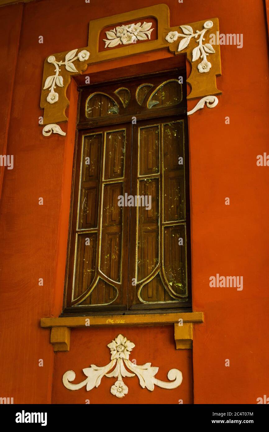 Antique window embellished with intricate wooden frame and botanical ...