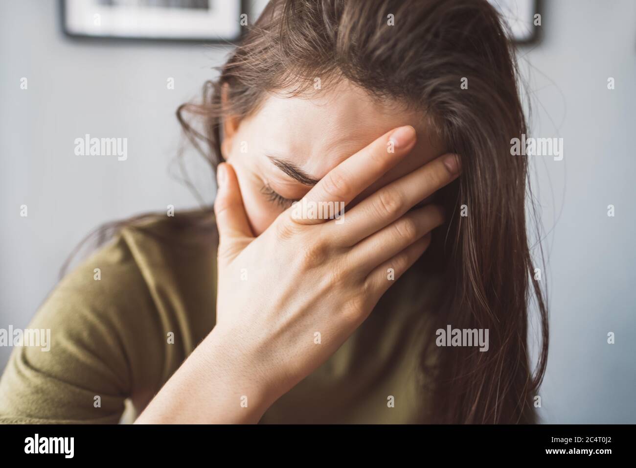 Tired young female touching forehead having headache migraine or ...