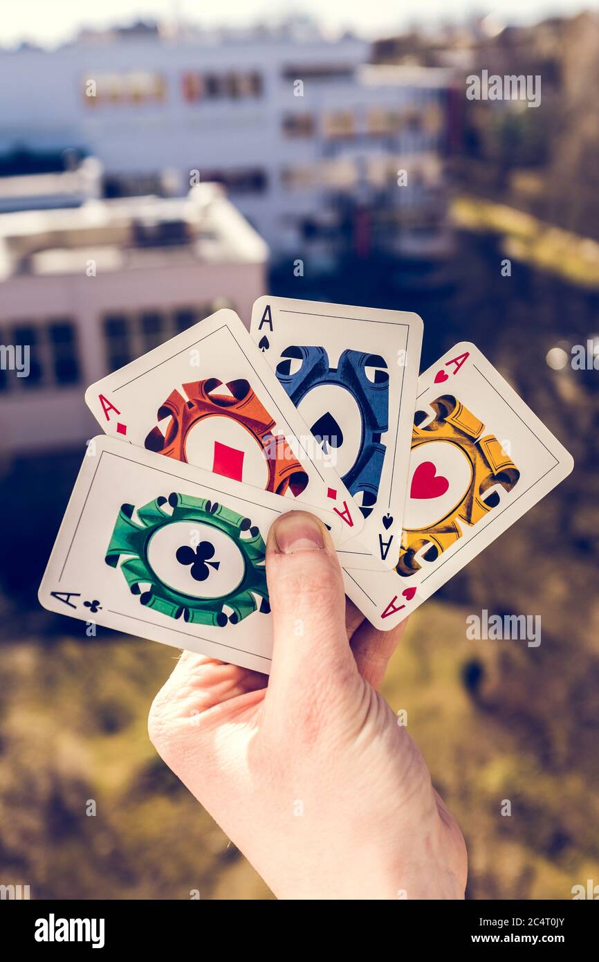 Vertical shot of a person holding four types of cards in his hand ...