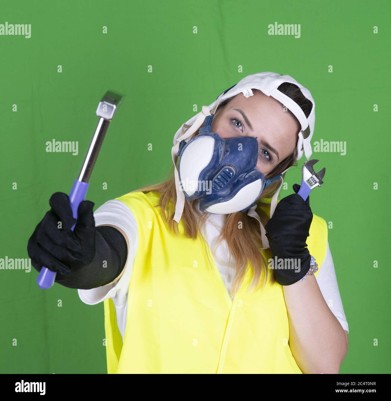 Female in a gas mask in a reflective security vest holding a hammer ...