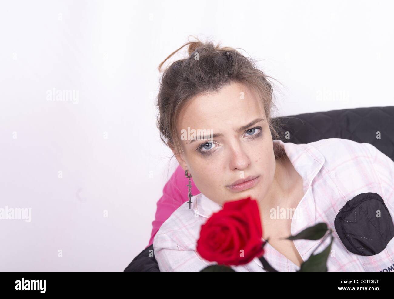 Portrait of a female with sad eyes holding a red rose Stock Photo - Alamy