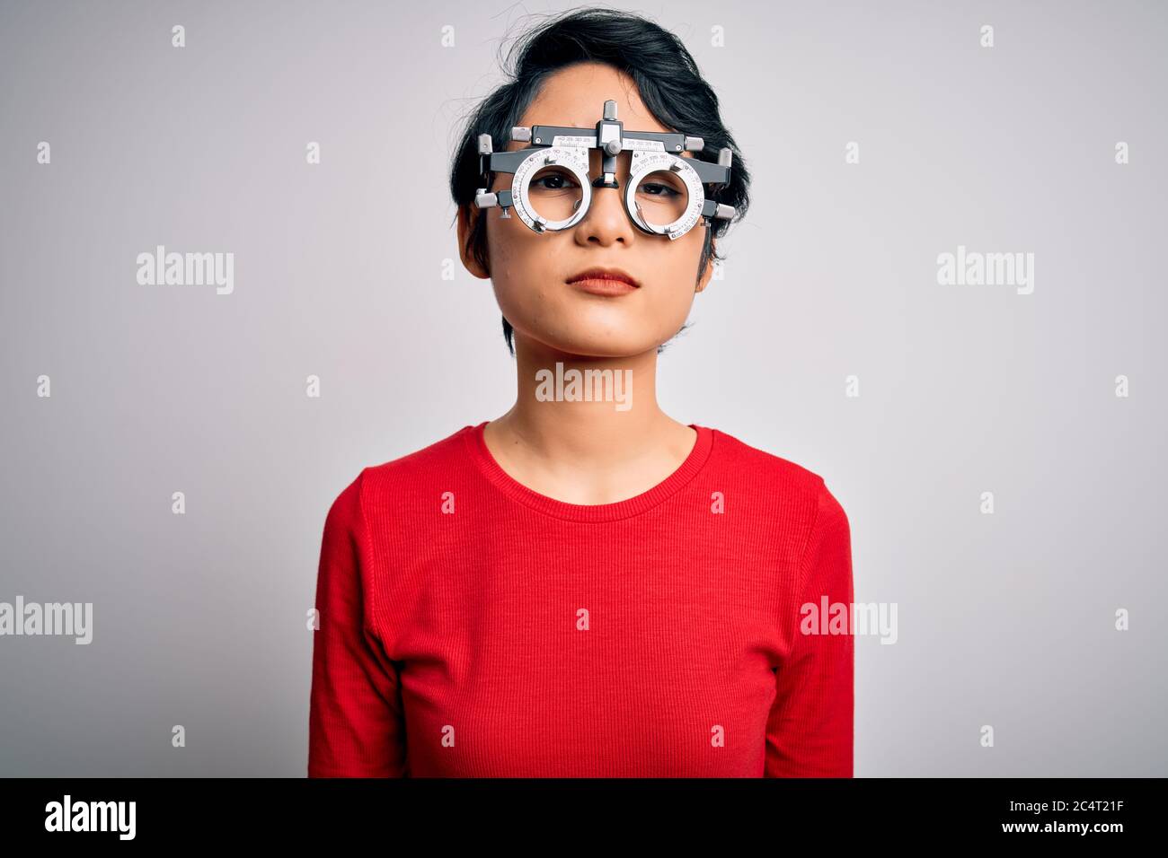 Young beautiful asian girl wearing optometry glasses standing over ...