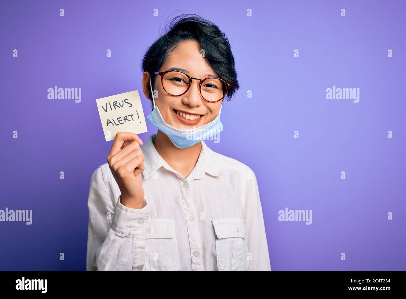 Young beautiful asian girl wearing medical mask holding reminder with ...