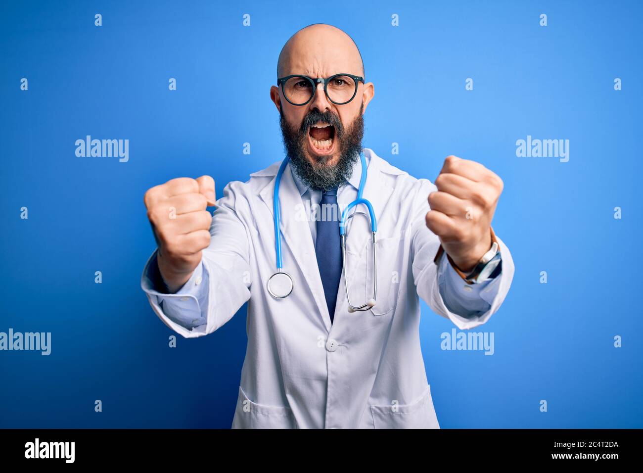 Handsome bald doctor man with beard wearing glasses and stethoscope ...