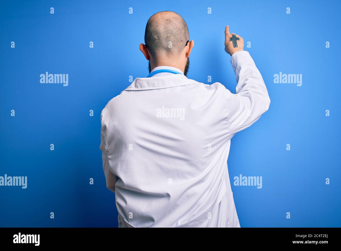 Handsome bald doctor man with beard wearing glasses and stethoscope ...