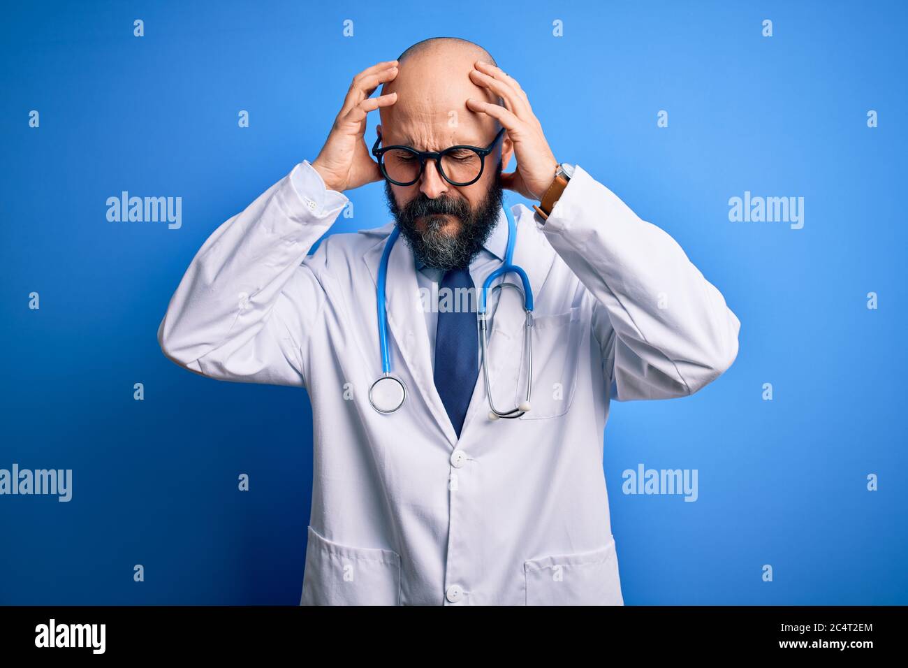 Handsome bald doctor man with beard wearing glasses and stethoscope ...