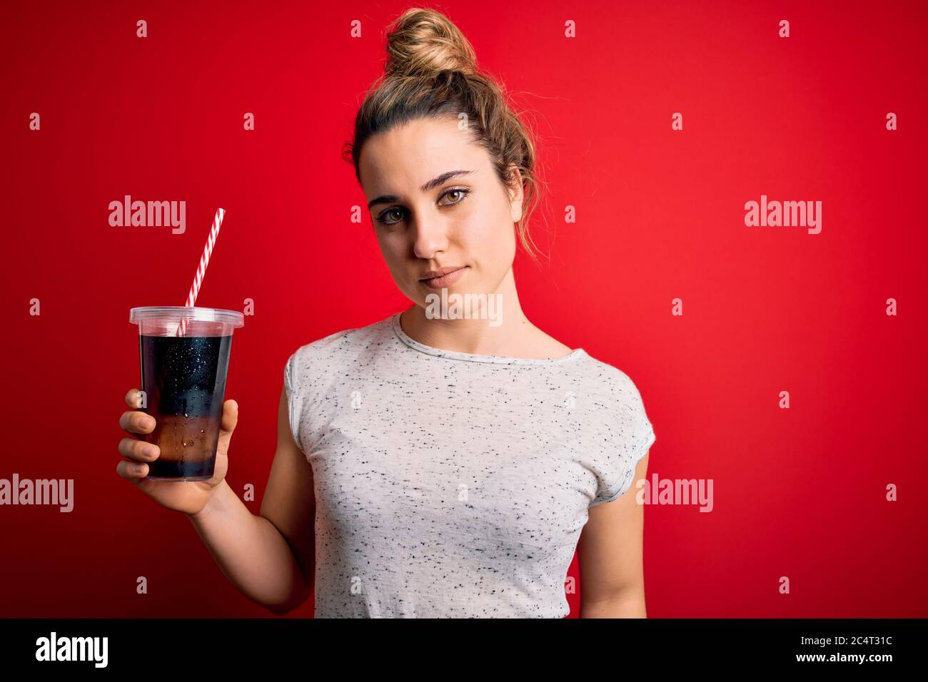 Beautiful blonde woman drinking cola fizzy beverage to refreshment over ...