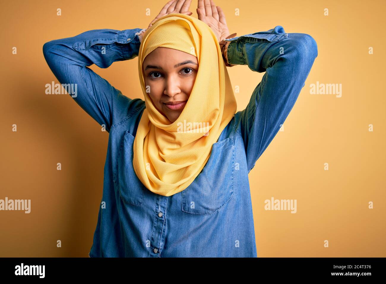 Young beautiful woman with curly hair wearing arab traditional hijab ...