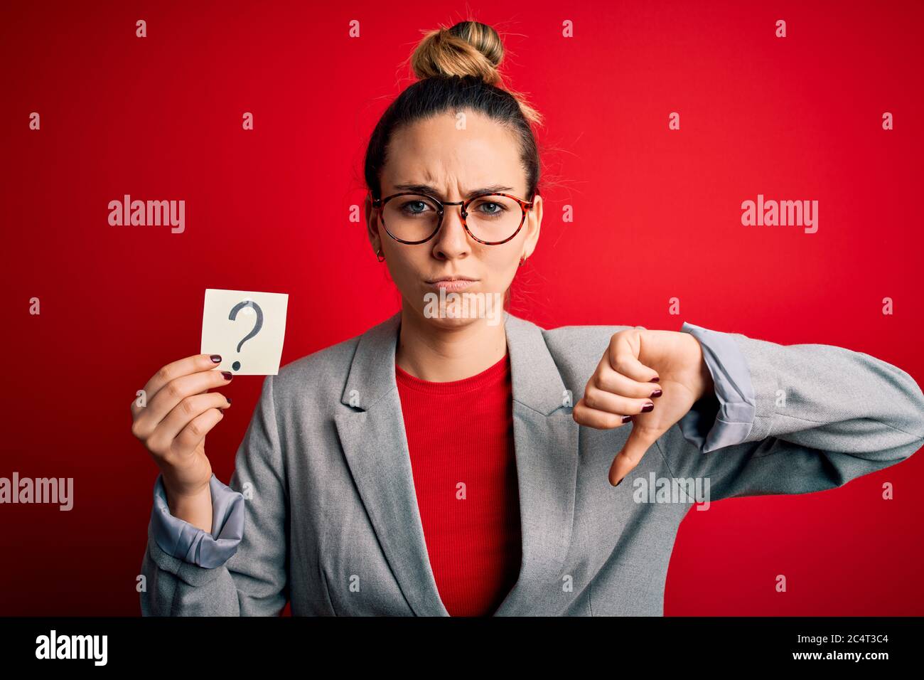 Young beautiful blonde woman with blue eyes holding reminder paper with ...