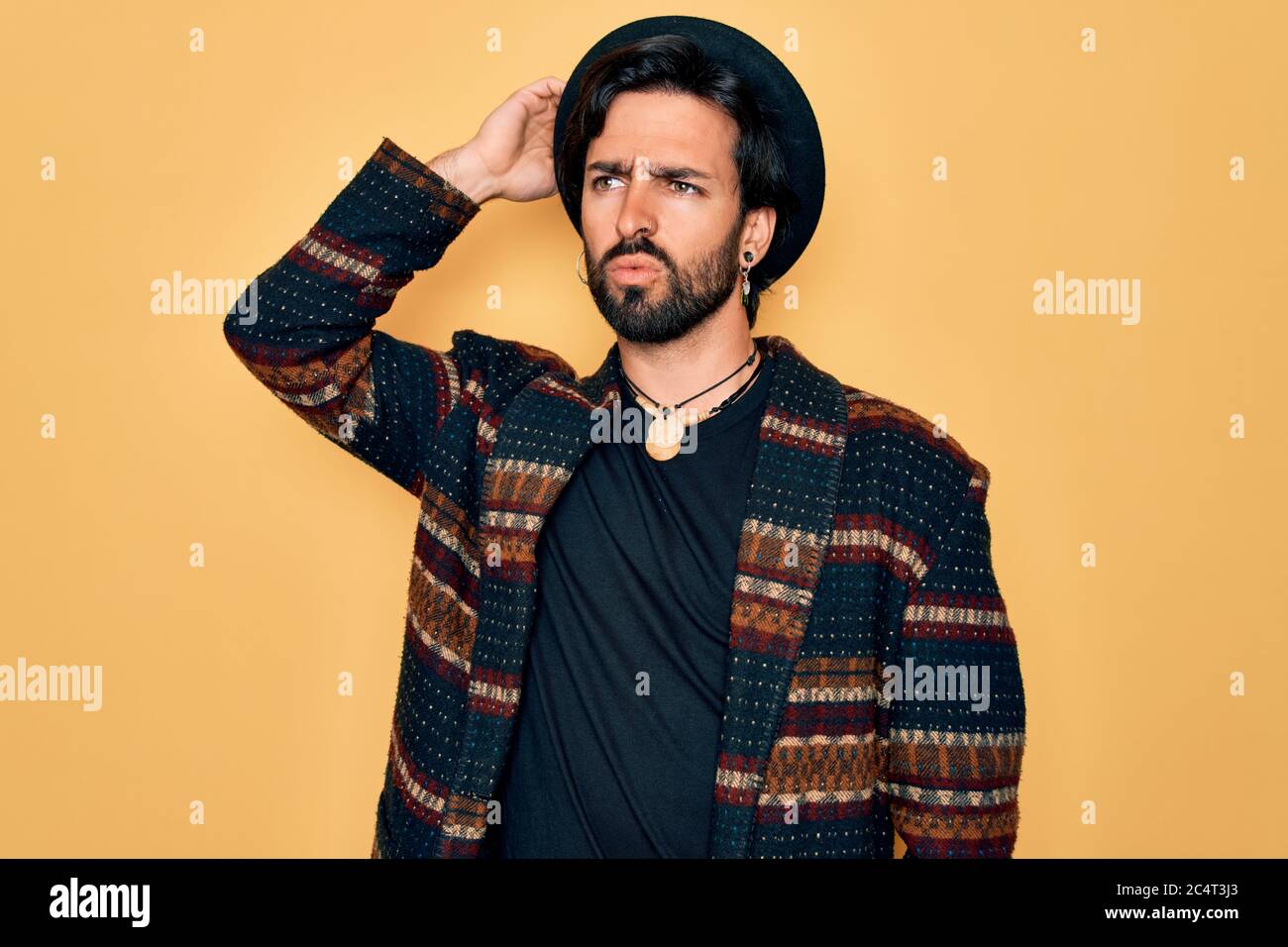 Young handsome hispanic bohemian man wearing hippie style and boho hat ...