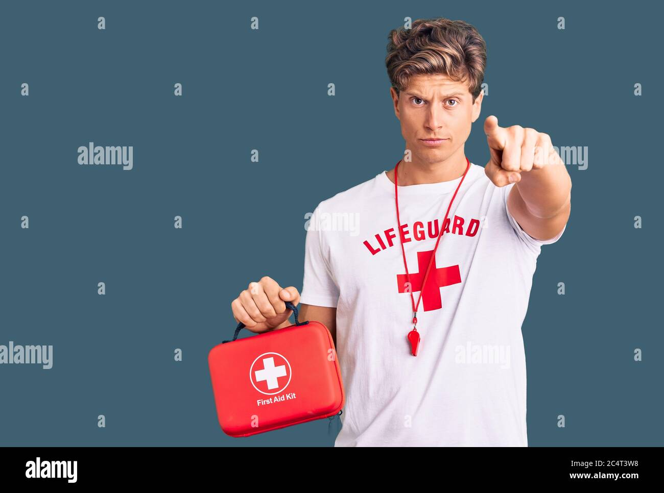 Young handsome man wearing lifeguard t shirt holding first aid kit ...