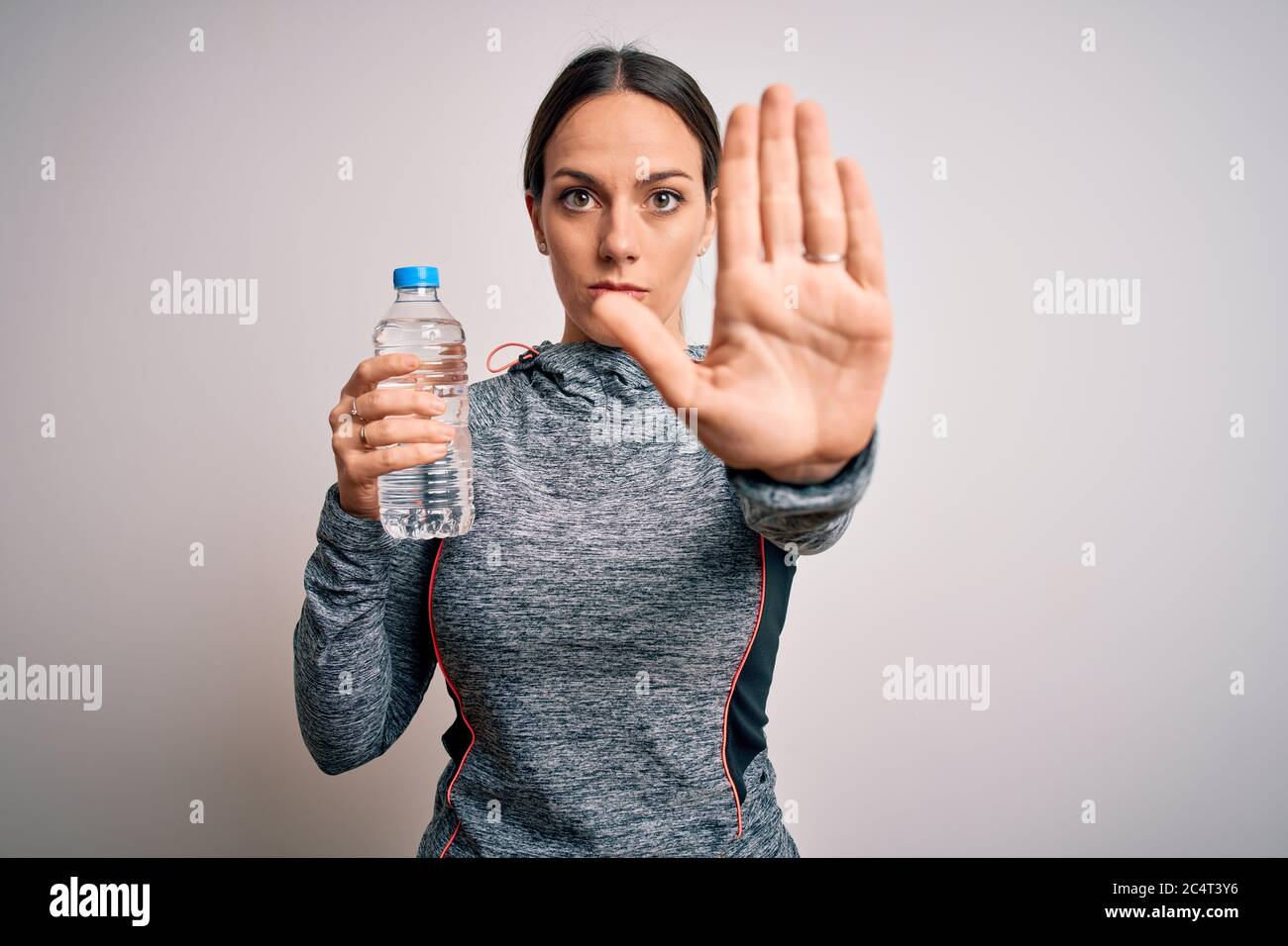 Young fitness woman wearing sport workout clothes drinking water from ...