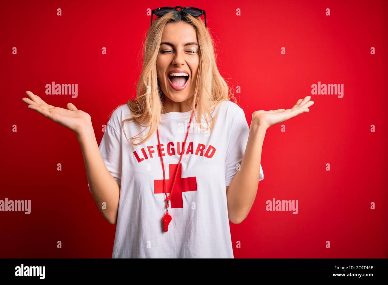 Young beautiful blonde lifeguard woman wearing t-shirt with red cross ...
