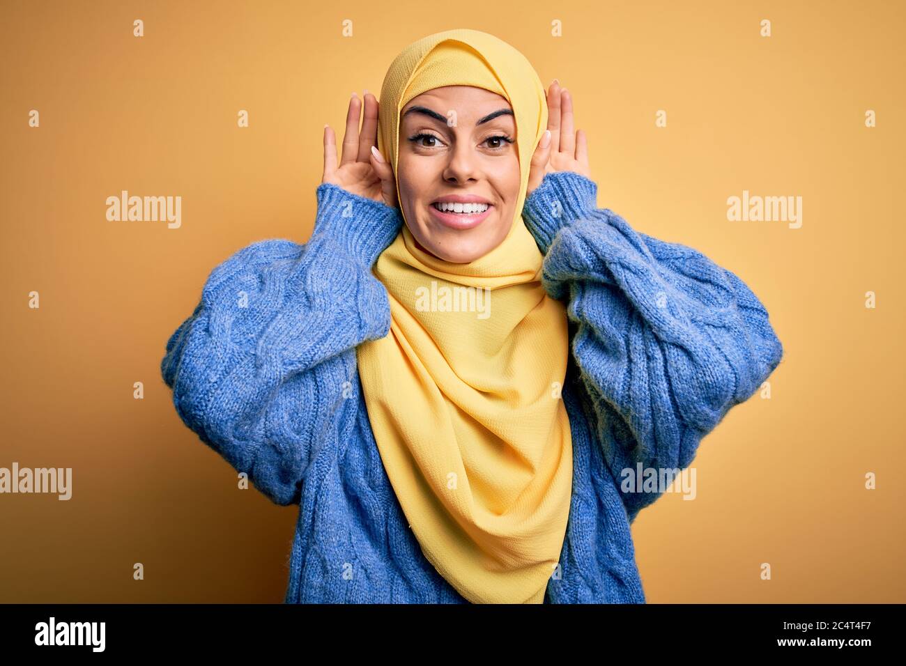 Young beautiful brunette muslim woman wearing arab hijab over isolated ...