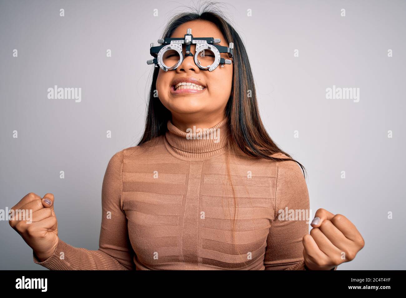 Young asian optical girl controlling eyesight using optometry glasses ...
