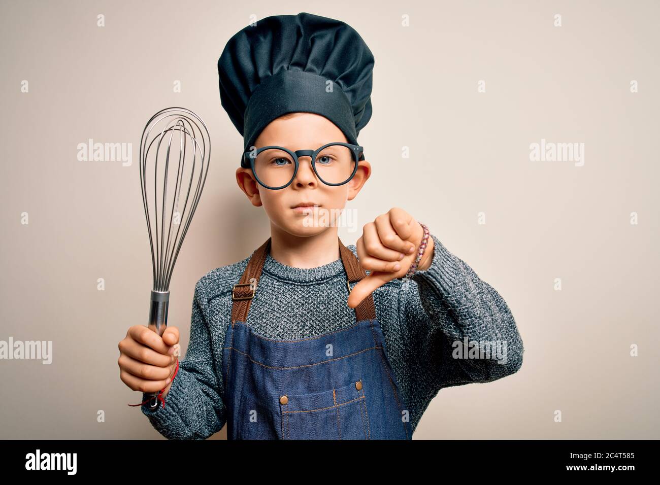 Young little caucasian cook kid wearing chef uniform and hat using ...