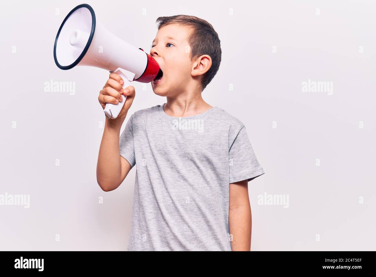 Adorable caucasian kid boy with angry expression. Screaming loud using ...
