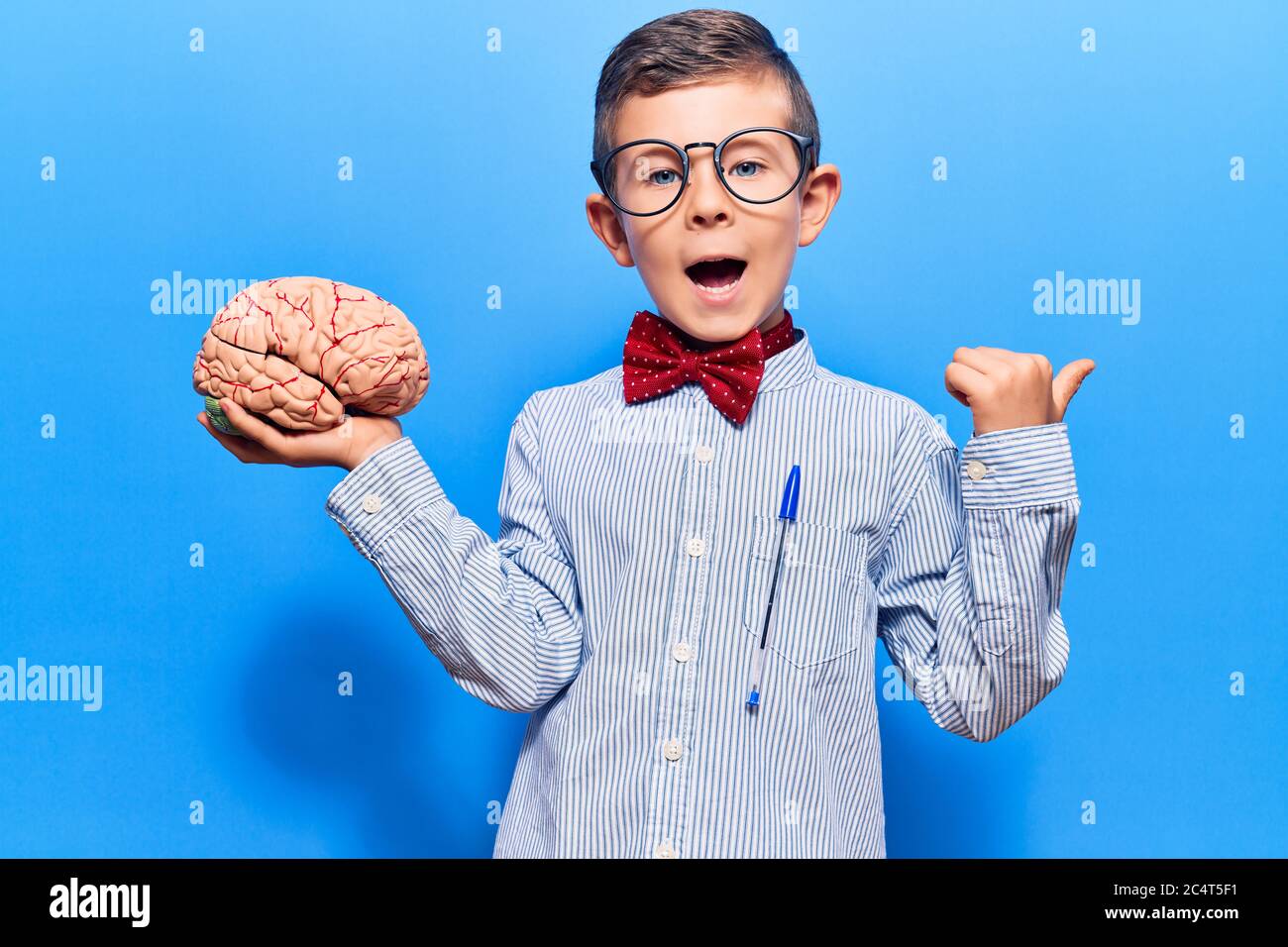 Cute blond kid wearing nerd bow tie and glasses holding brain pointing ...