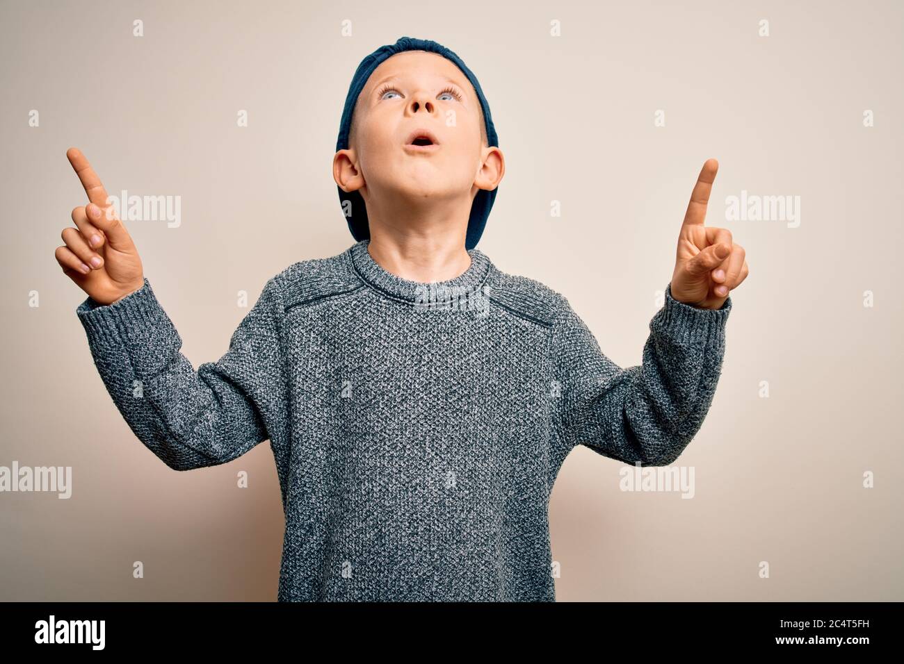 Young little caucasian kid with blue eyes wearing wool cap over ...