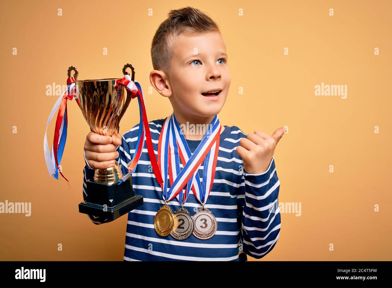 Young little caucasian kid wearing winner medals and victory award ...