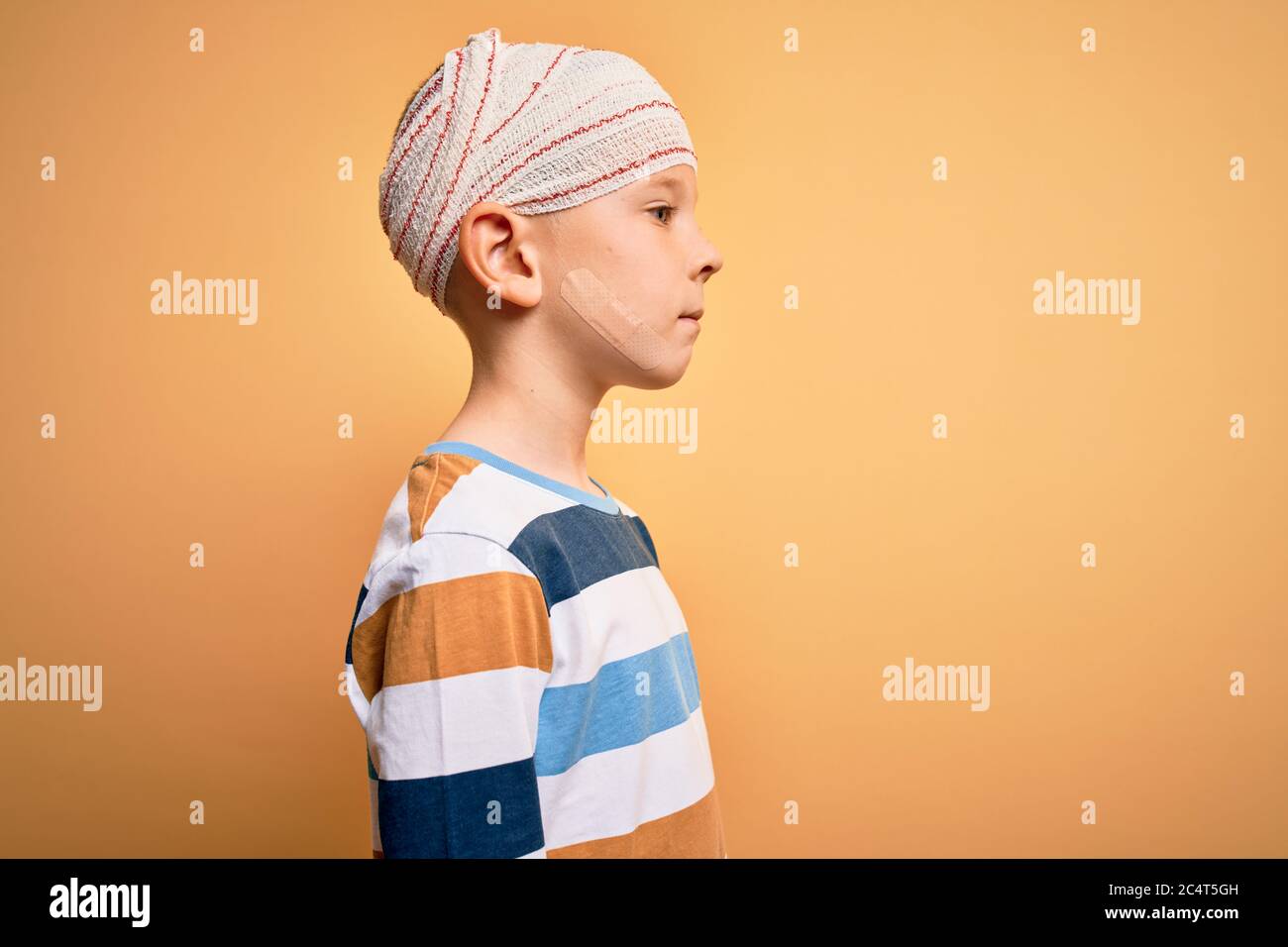 Young little caucasian kid injured wearing medical bandage on head over ...