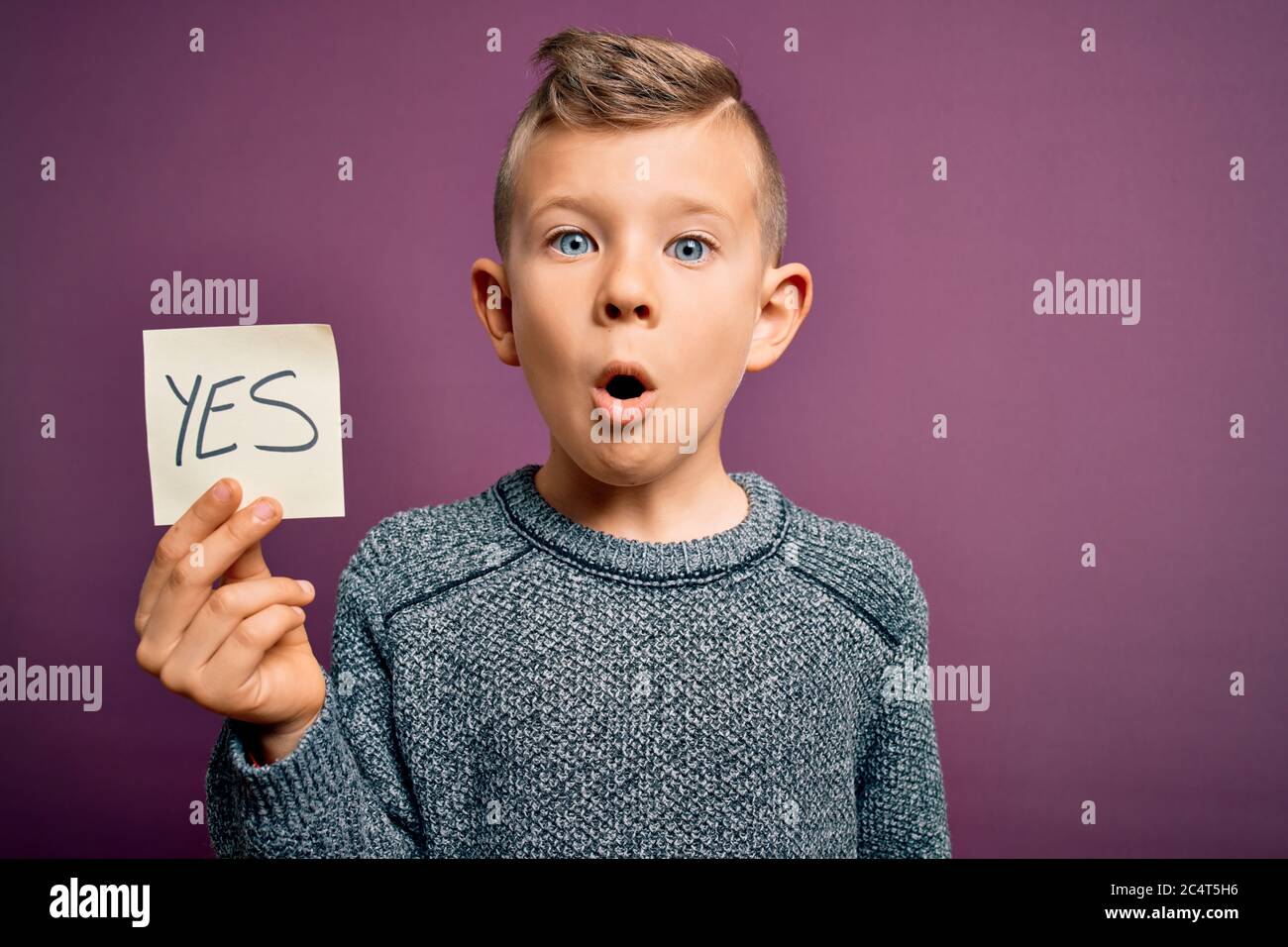 Young little caucasian kid showing YES word on a paper note as positive ...