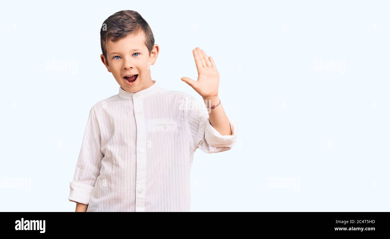 Cute blond kid wearing elegant shirt waiving saying hello happy and ...