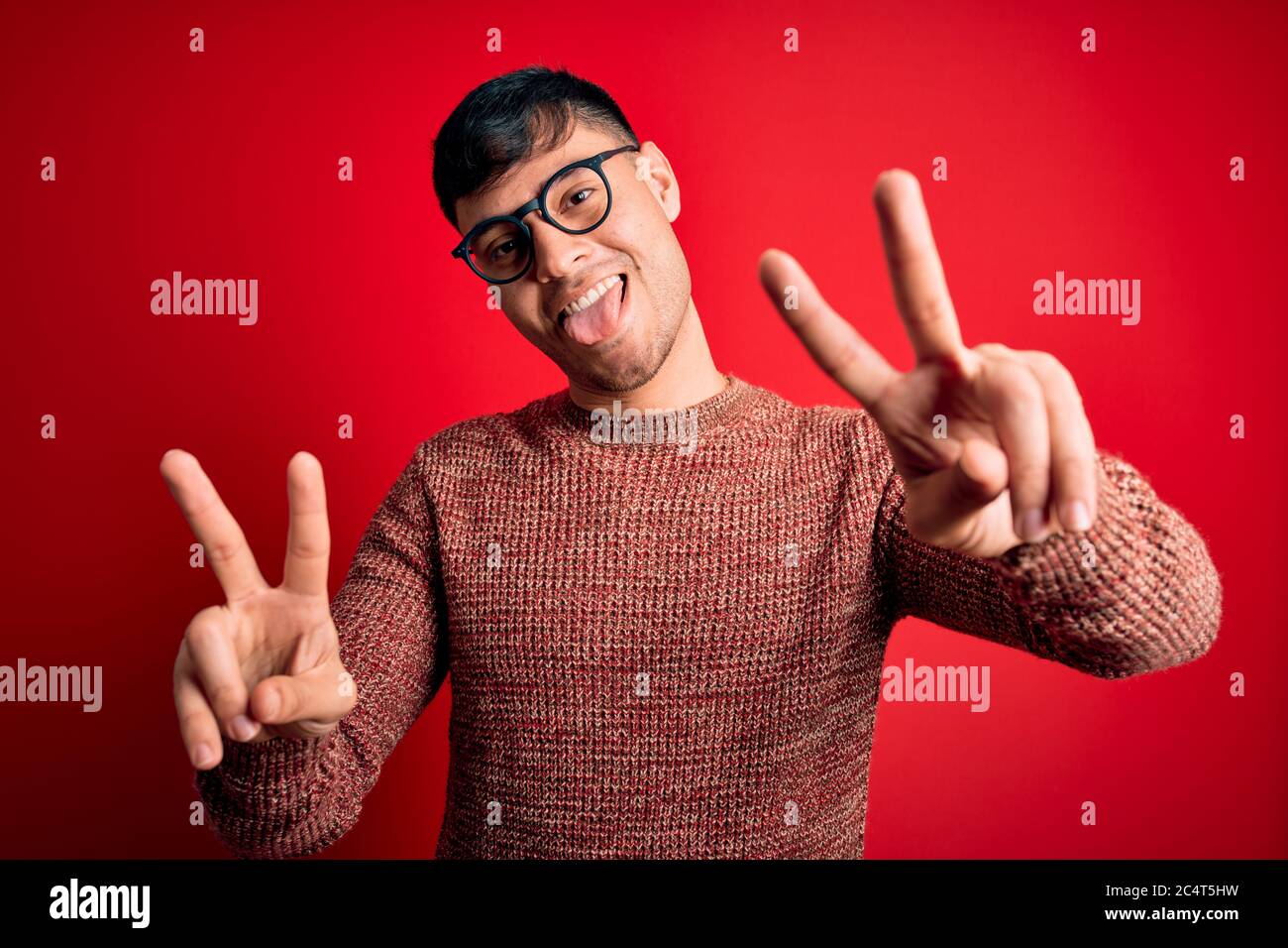 Young handsome hispanic man wearing nerd glasses over red background ...