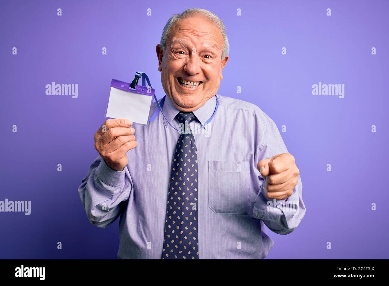 Senior grey haired business man holding identification tag over purple ...