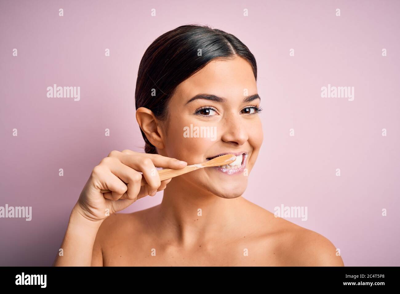 Young beautiful brunette woman brushing her teeth using tooth brush and ...