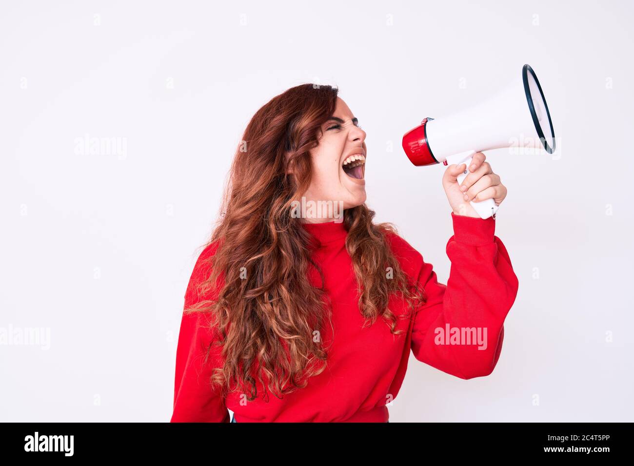 Young beautiful brunette woman screaming using megaphone over isolated ...