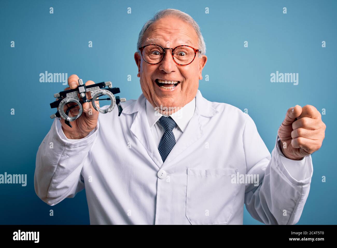 Senior grey haired optic doctor man holding optometrist eyeglasses over ...
