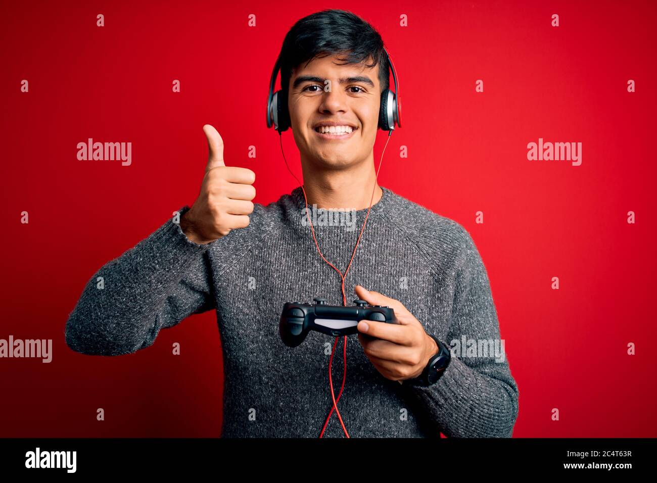 Young handsome gamer man playing video game using joystick and ...
