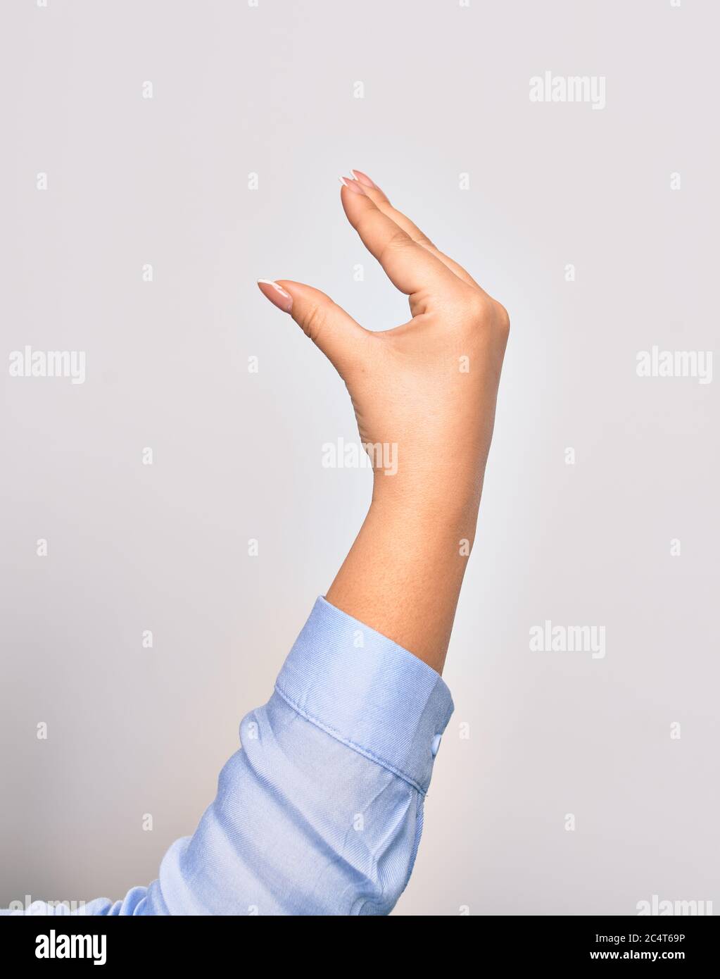 Hand of caucasian young woman doing catch sign over isolated white ...