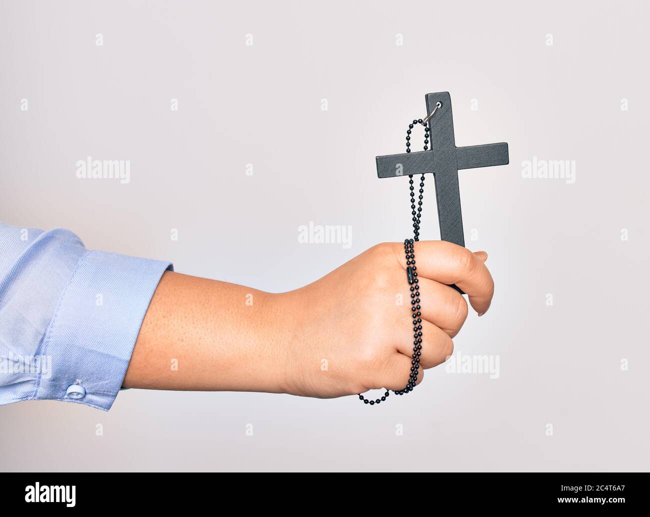 Hand of caucasian young catholic woman holding christian cross over ...