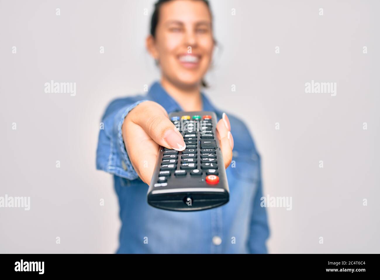 Woman changing television channel holding tv remote control. Standing ...