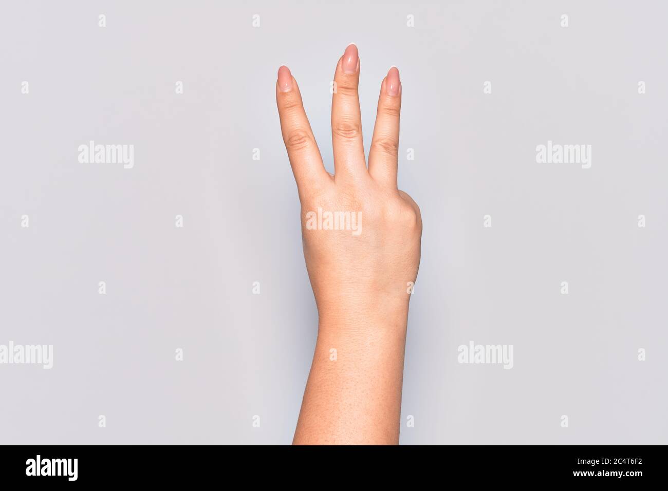 Hand of caucasian young woman counting number 3 showing three fingers ...