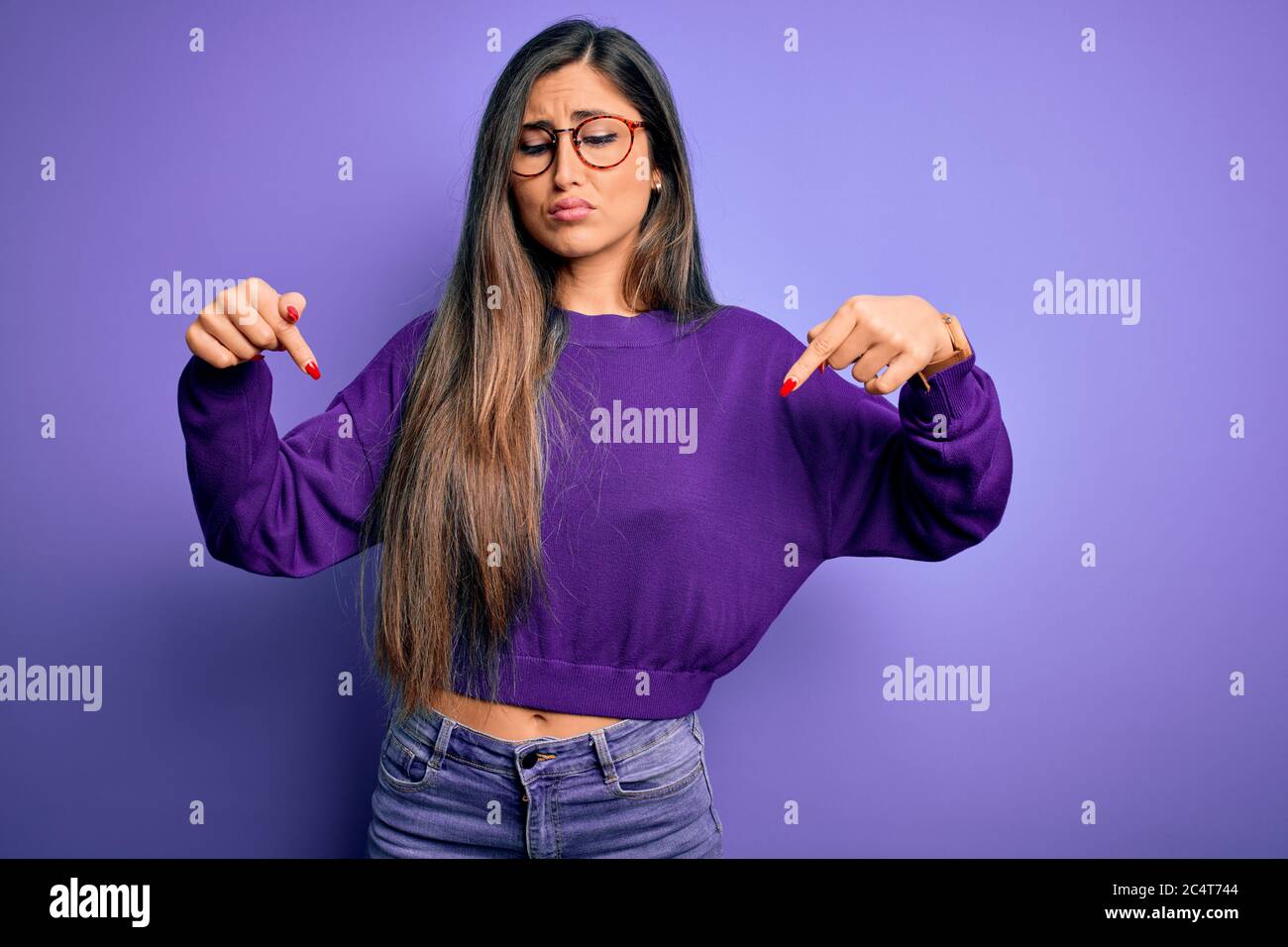 Young beautiful smart woman wearing glasses over purple isolated ...