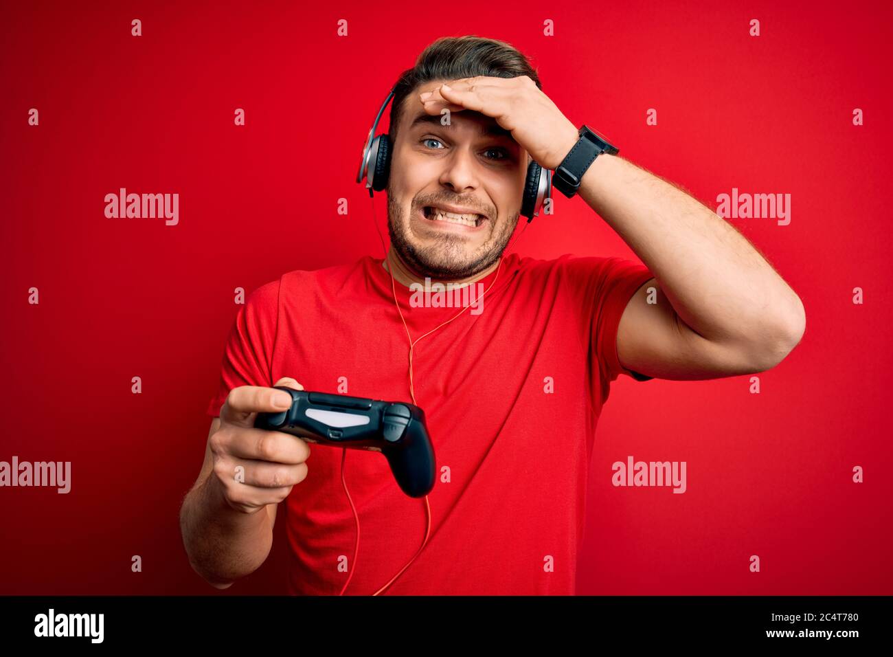 Young gamer man with blue eyes playing video games using gamepad ...