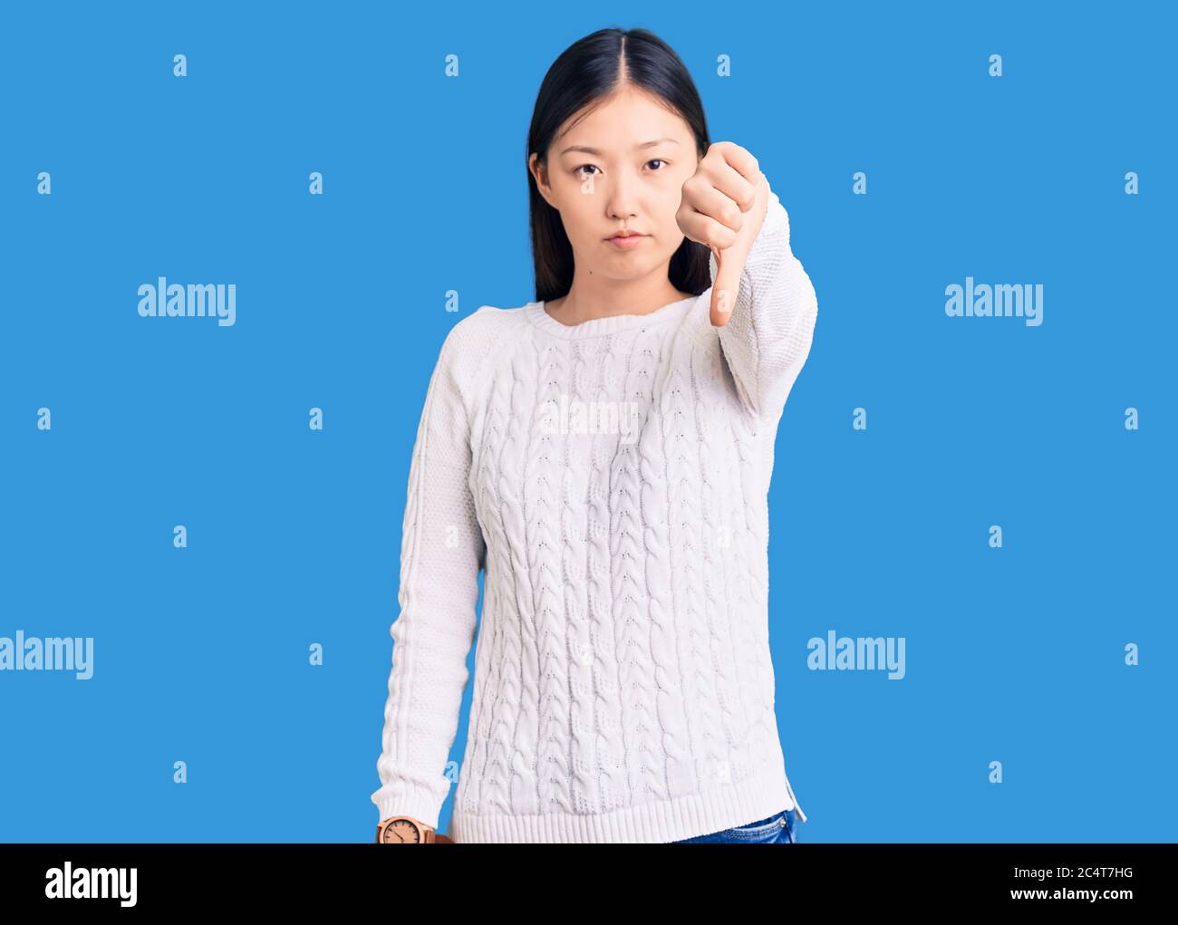 Young beautiful chinese woman wearing casual sweater looking unhappy ...