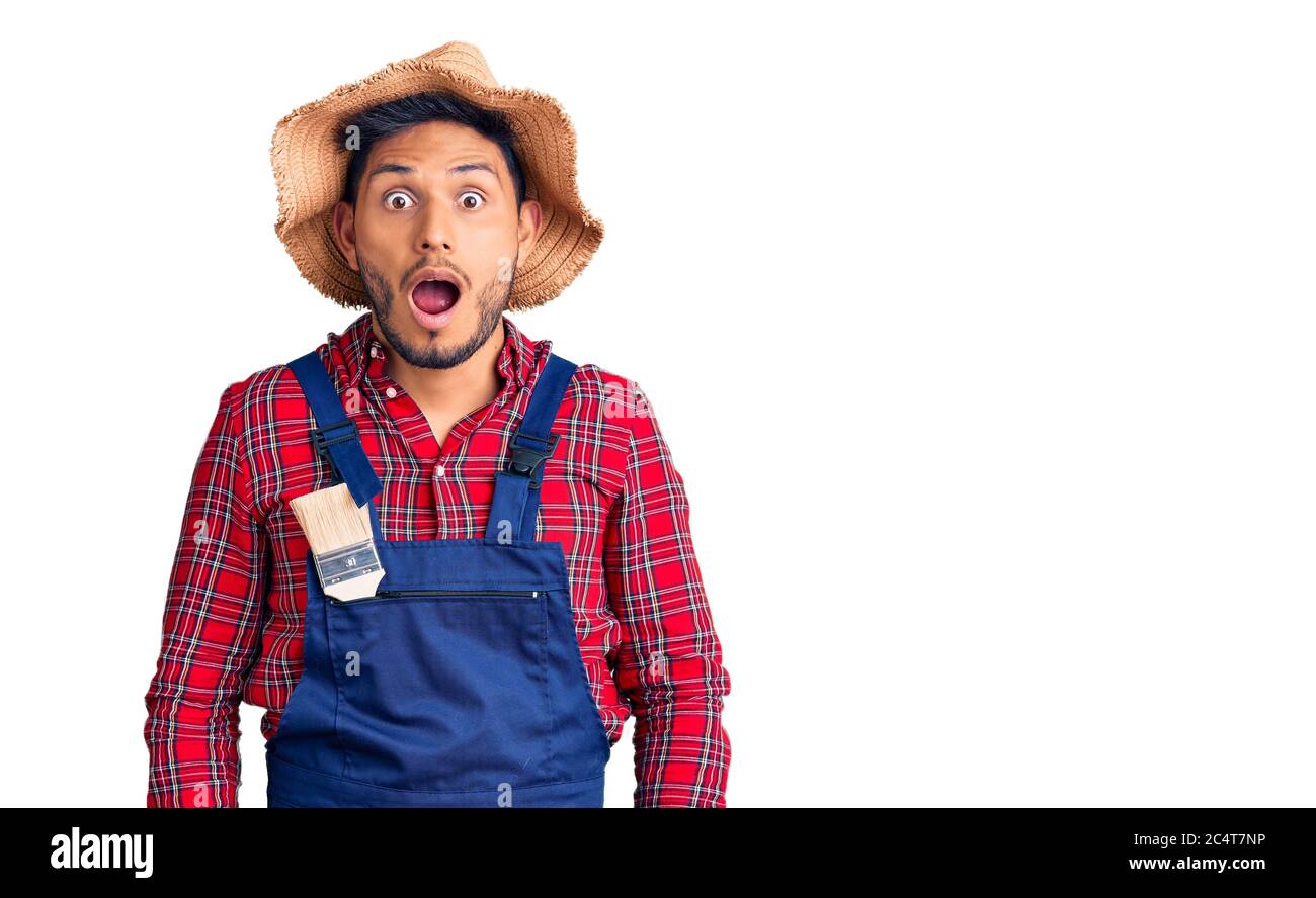 Handsome latin american young man weaing handyman uniform afraid and ...