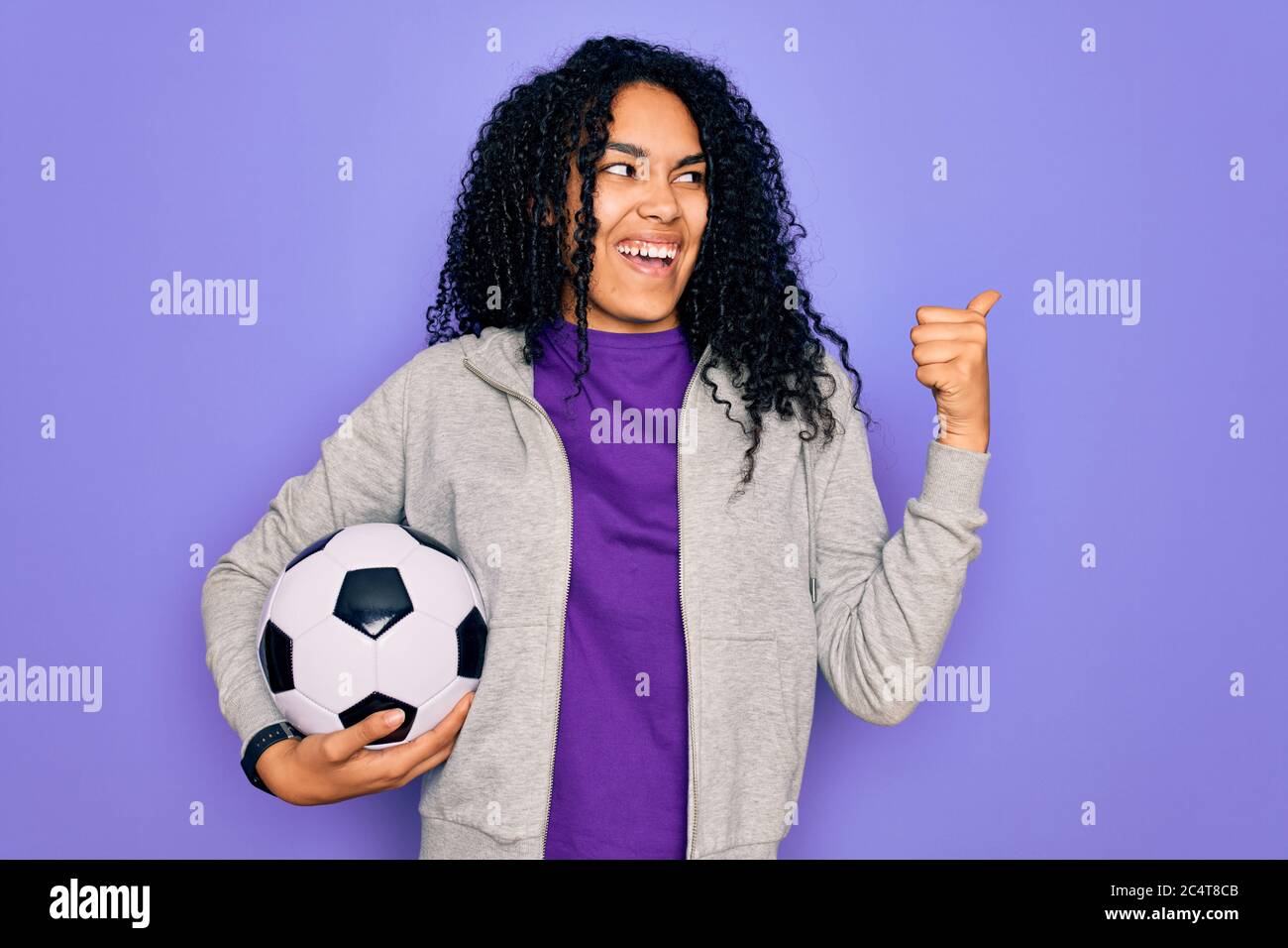 African american curly player woman playing soccer holding football bal ...