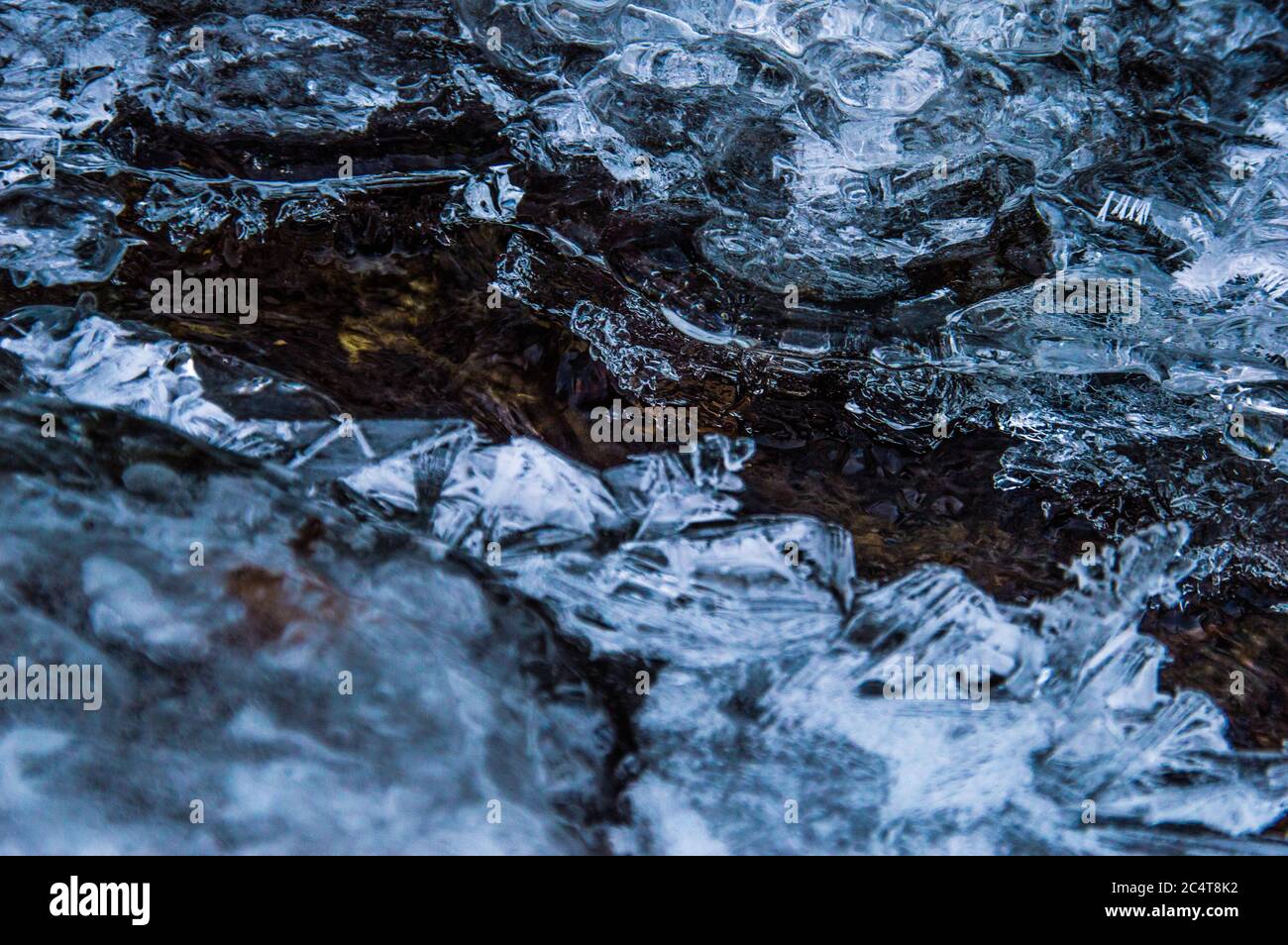 Closeup shot of flowing water surrounded with ice during winter Stock ...