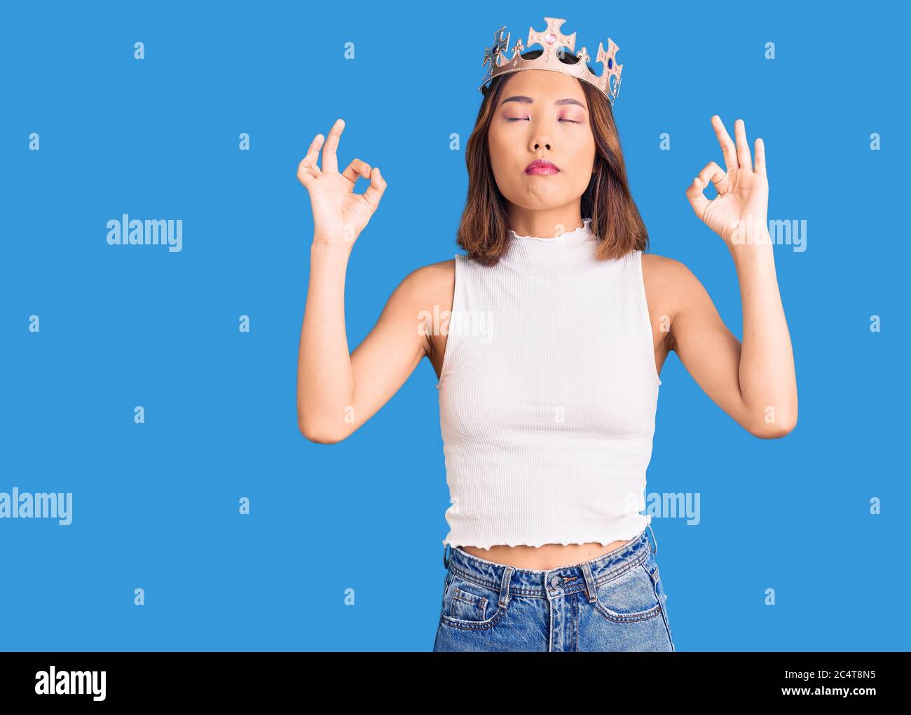 Young beautiful chinese girl wearing princess crown relax and smiling ...