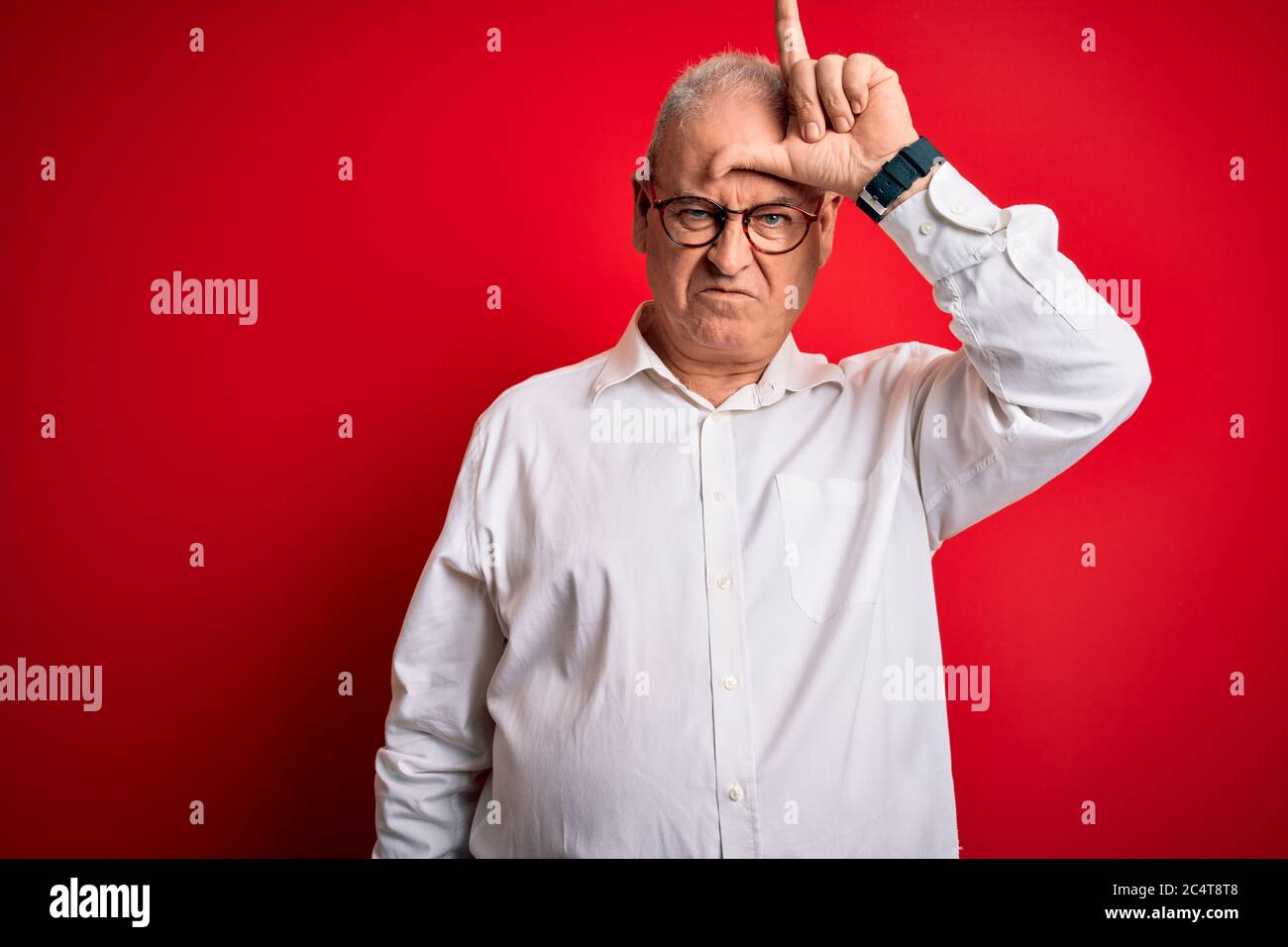 Middle age handsome hoary man wearing casual shirt and glasses over red ...